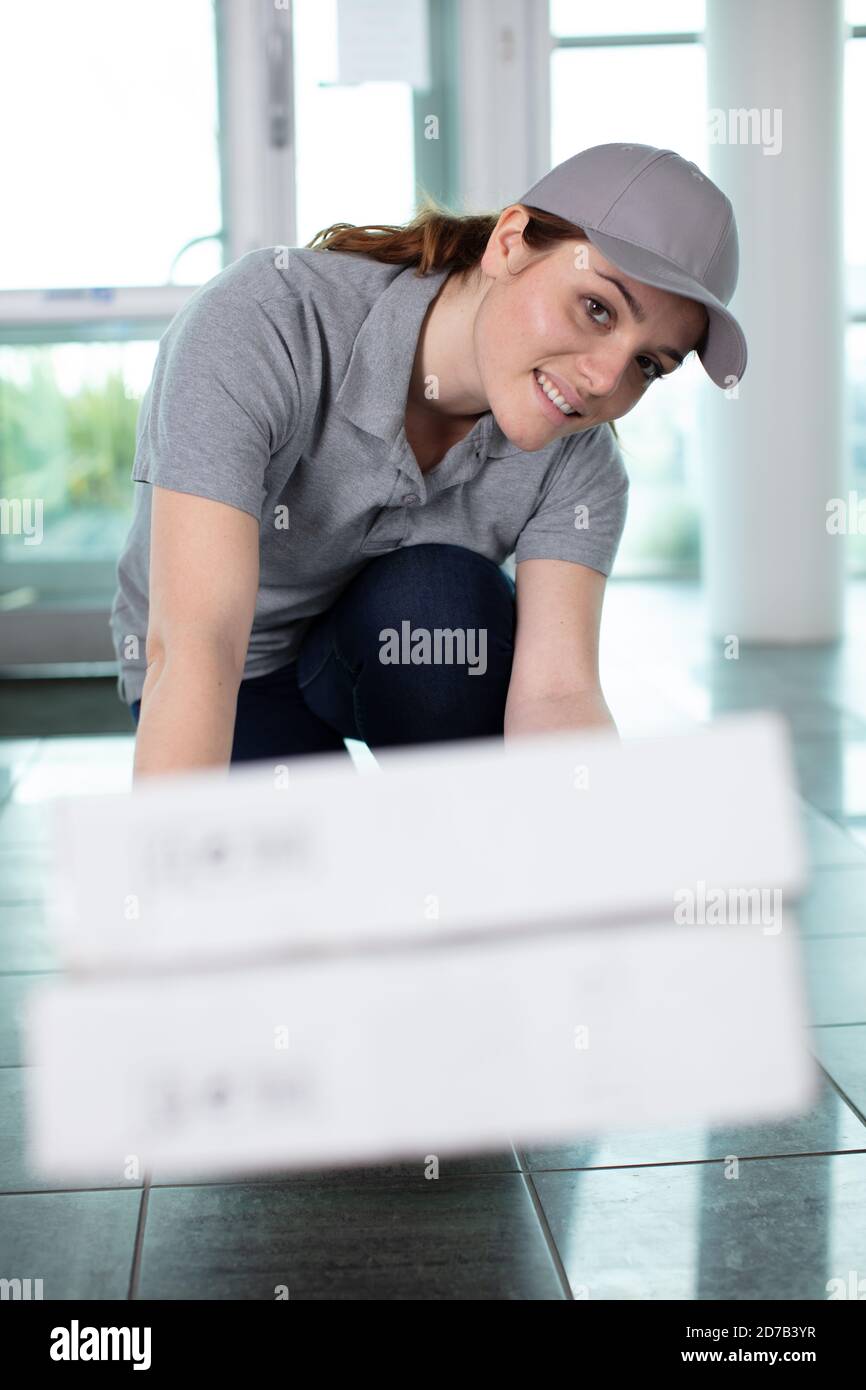 young woman lifting long package Stock Photo - Alamy