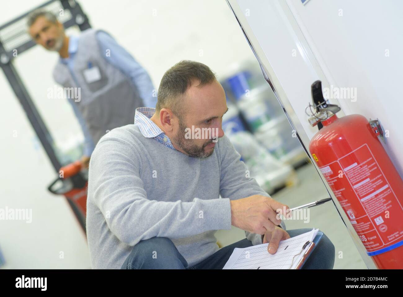a professional checking fire extinguisher Stock Photo - Alamy