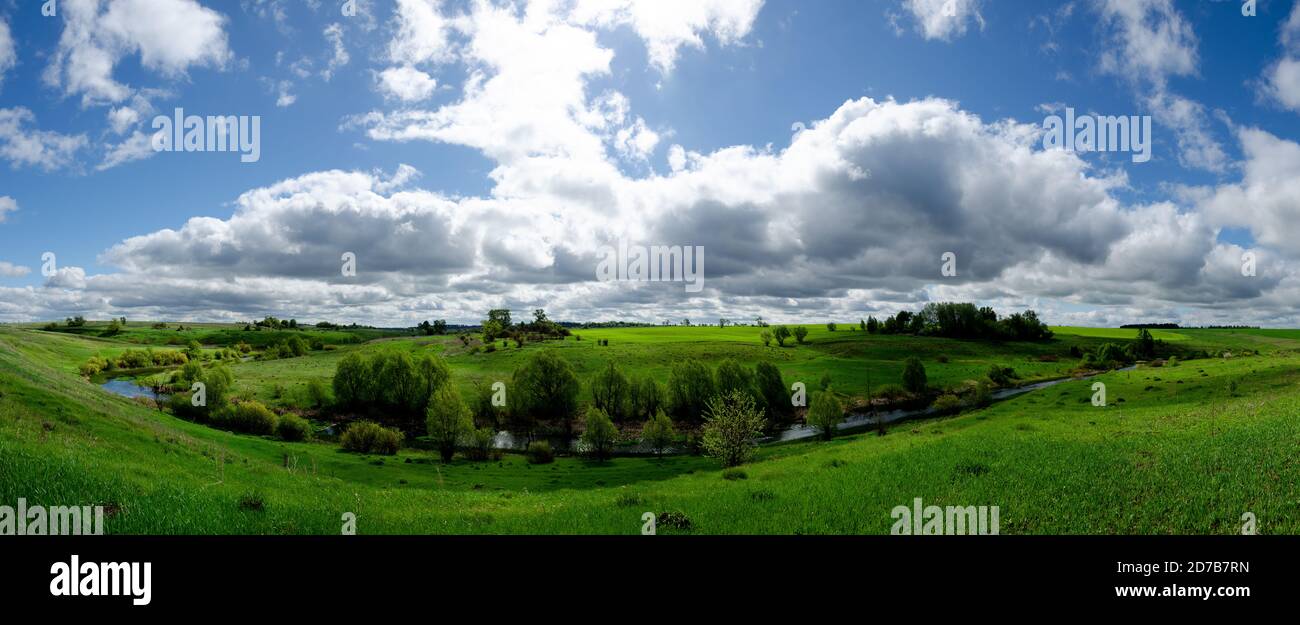 Sunny spring landscape with river and beautiful clouds in blue sky ...