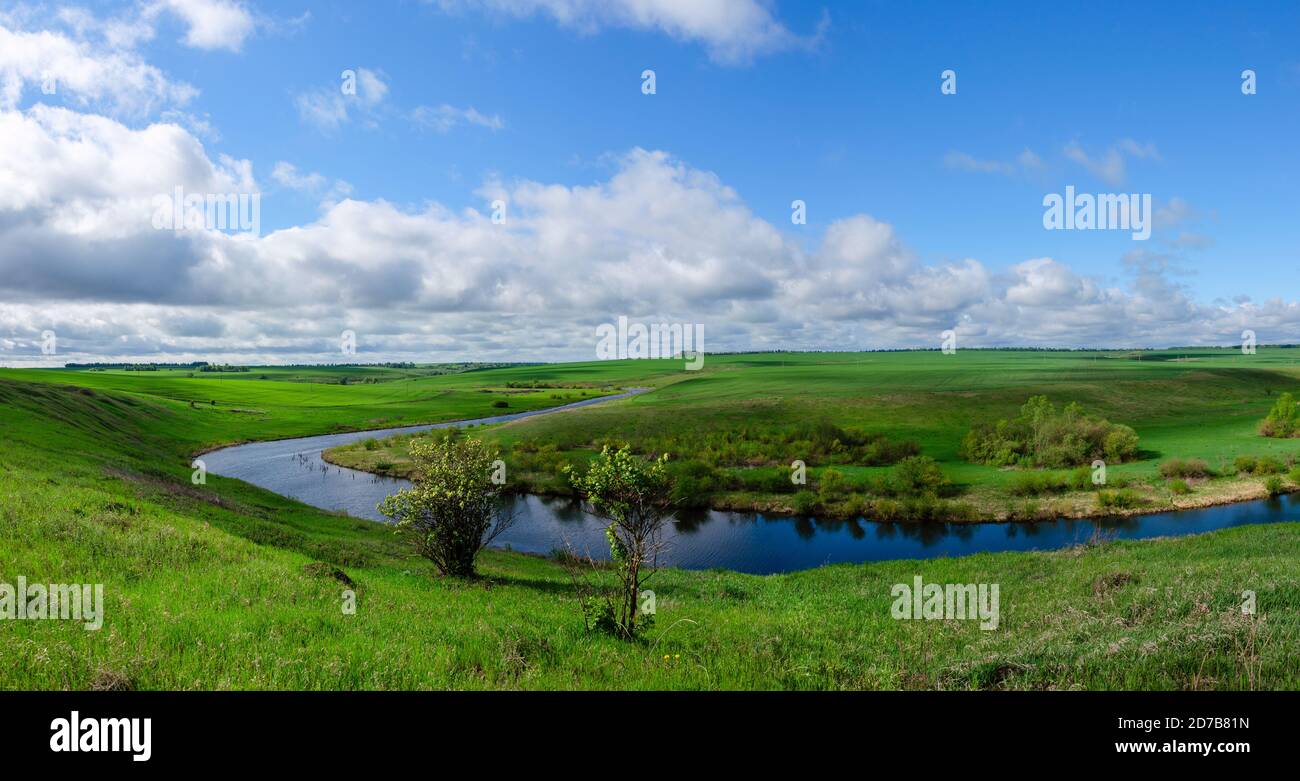 Sunny spring landscape with river and beautiful clouds in blue sky ...