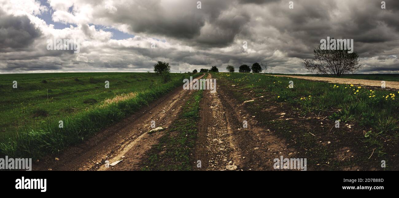 Dark stormy clouds in dramatic overcast sky over the ground country ...
