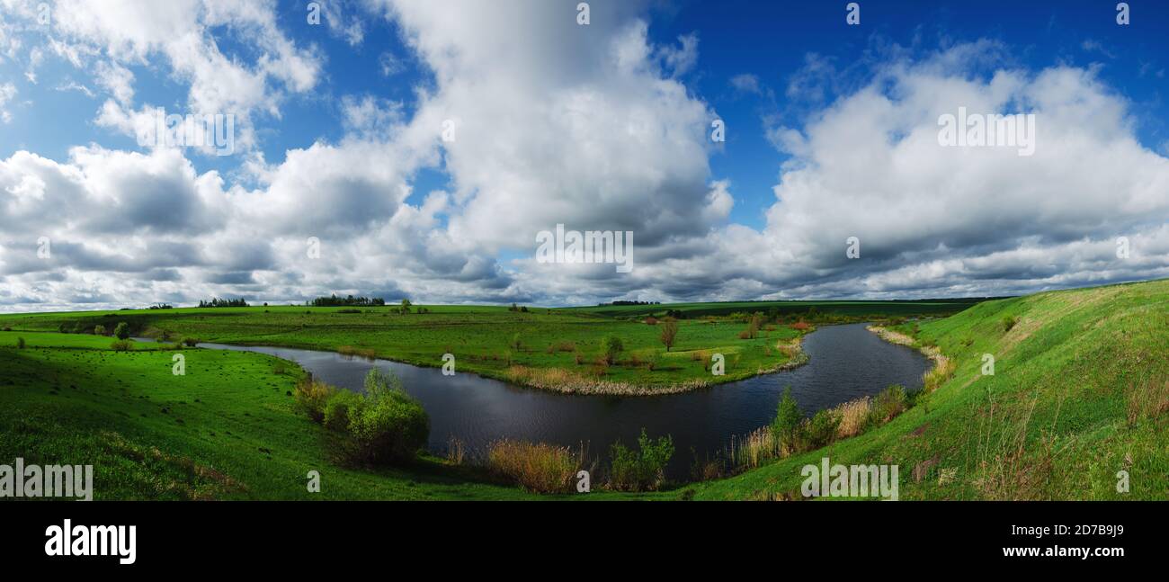 Sunny spring landscape with river and beautiful clouds in blue sky ...