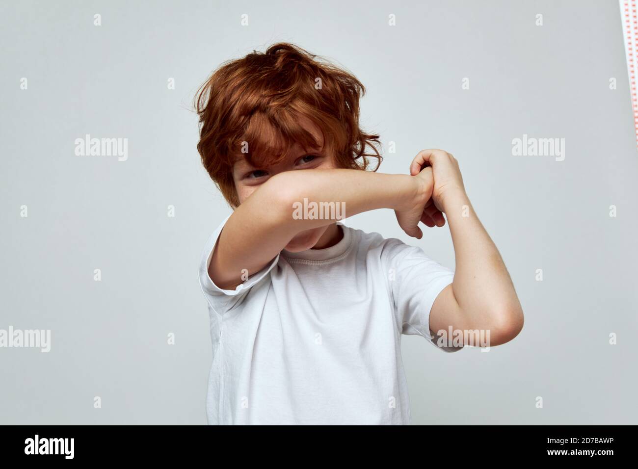 cute boy covering his face with hand white t-shirt studio Stock Photo ...