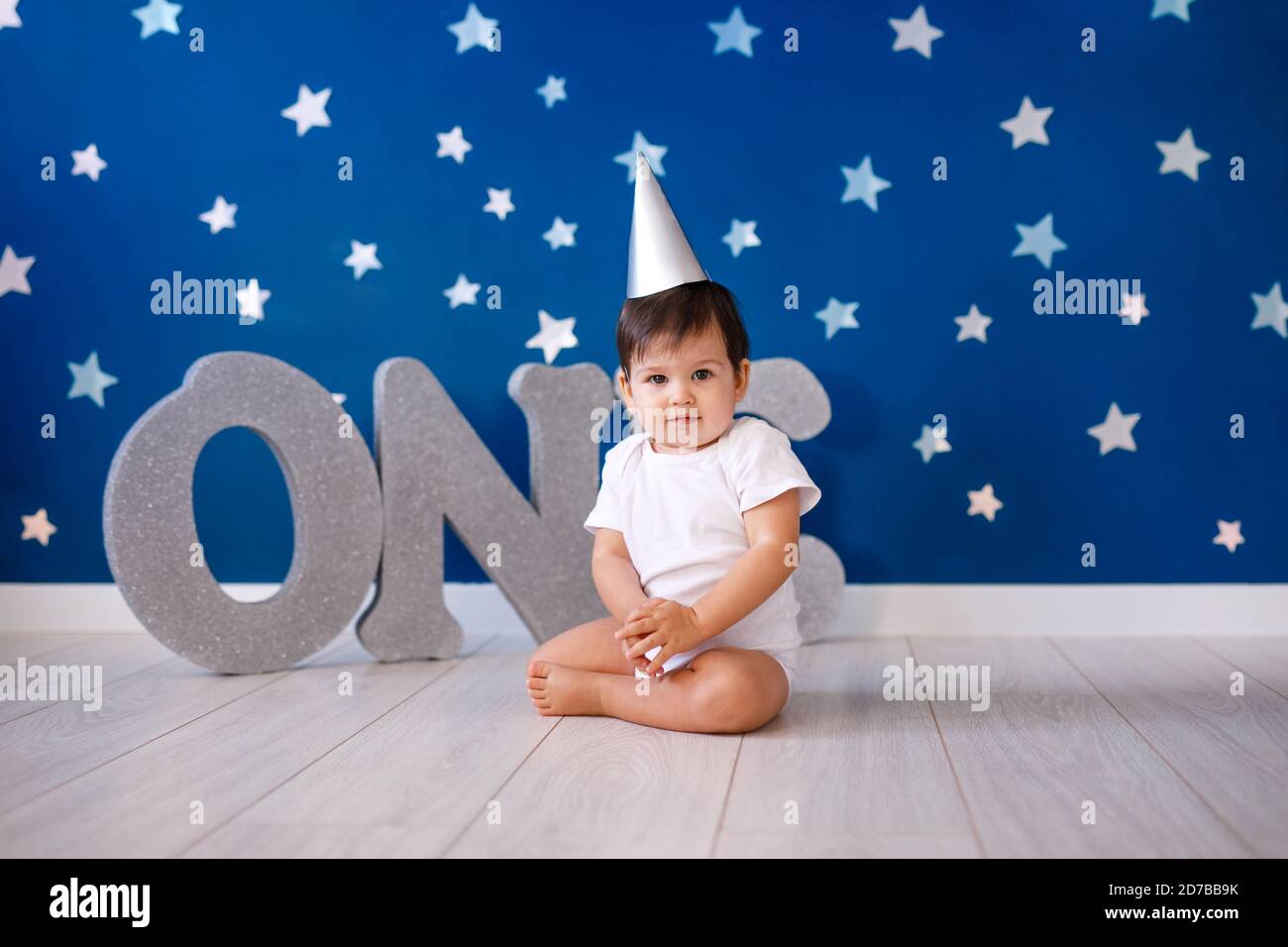 One Year Old Baby Boy Celebrates Birthday Near Silver Letters ONE On one-year-old-baby-boy-celebrates-birthday-near-silver-letters-one-on
