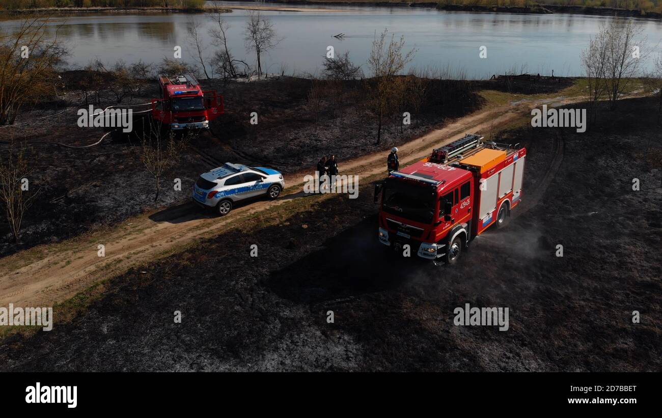Wildfire aftermath - Firefighter engine and police car at burned area ...
