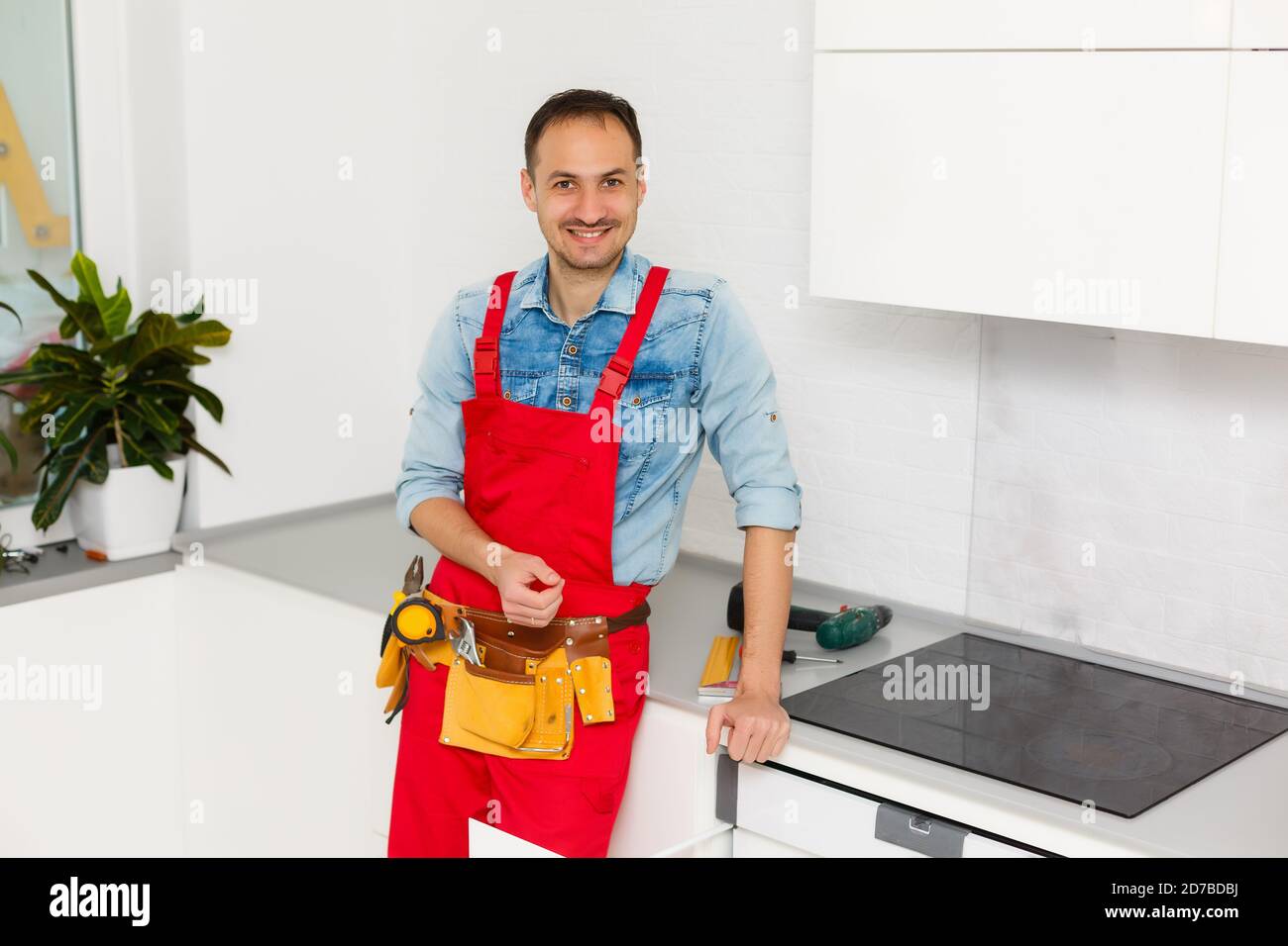 kitchen installation. Worker assembling furniture Stock Photo - Alamy