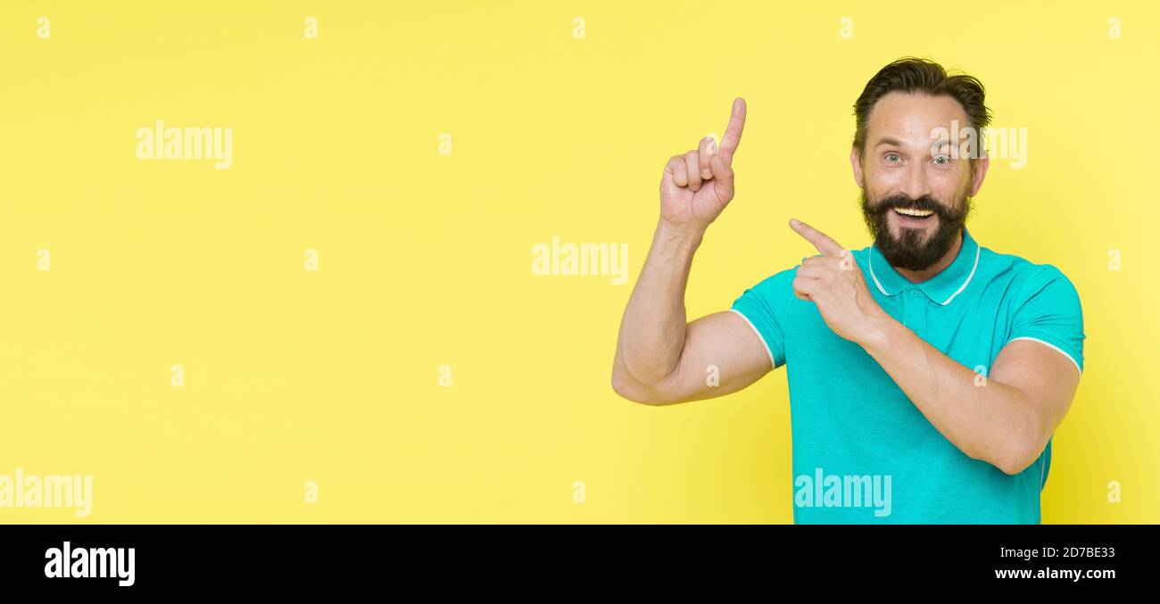 Pointing direction. Man pointing index fingers yellow background. Guy ...