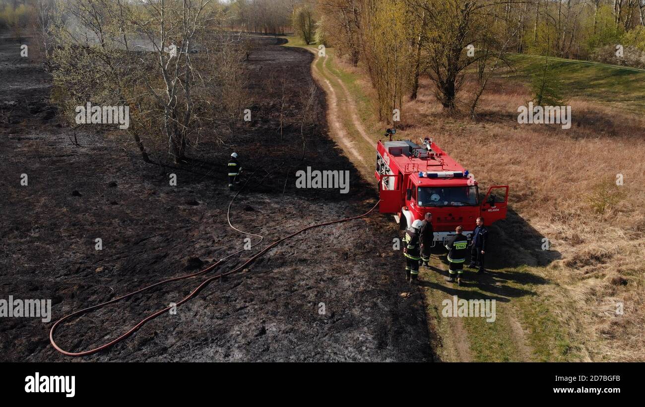 Firefighter engine extinguishing the burned meadow - wildfire - aerial ...