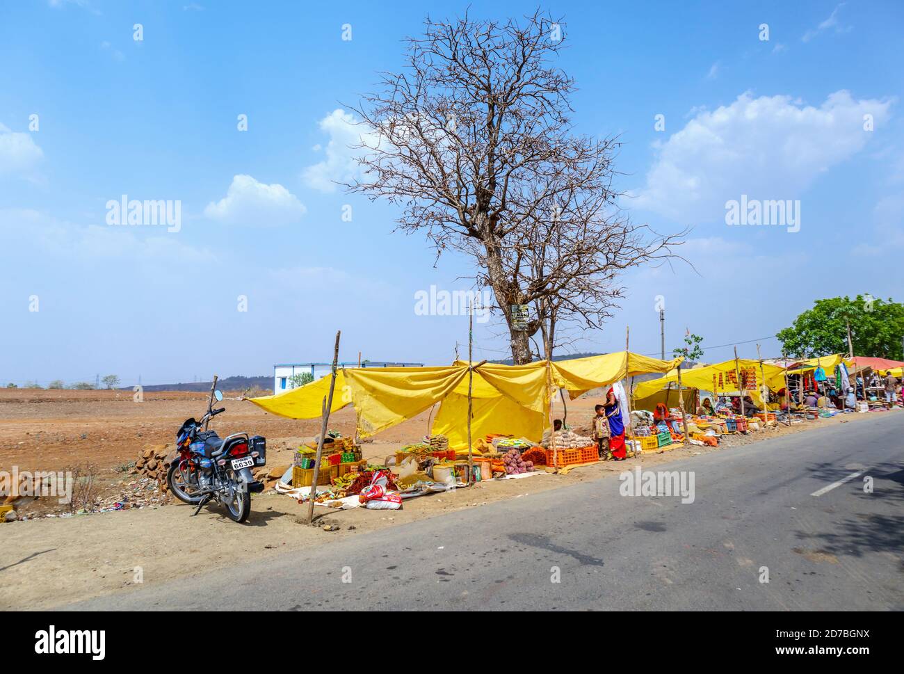 Temporary stalls selling local produce and goods in a roadside market ...