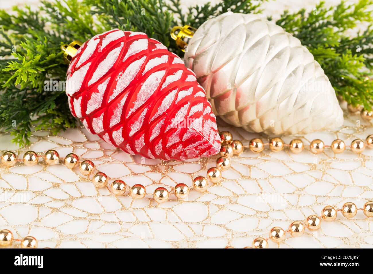 Christmas decoration with fir tree branch, cones, and beads on golden ...