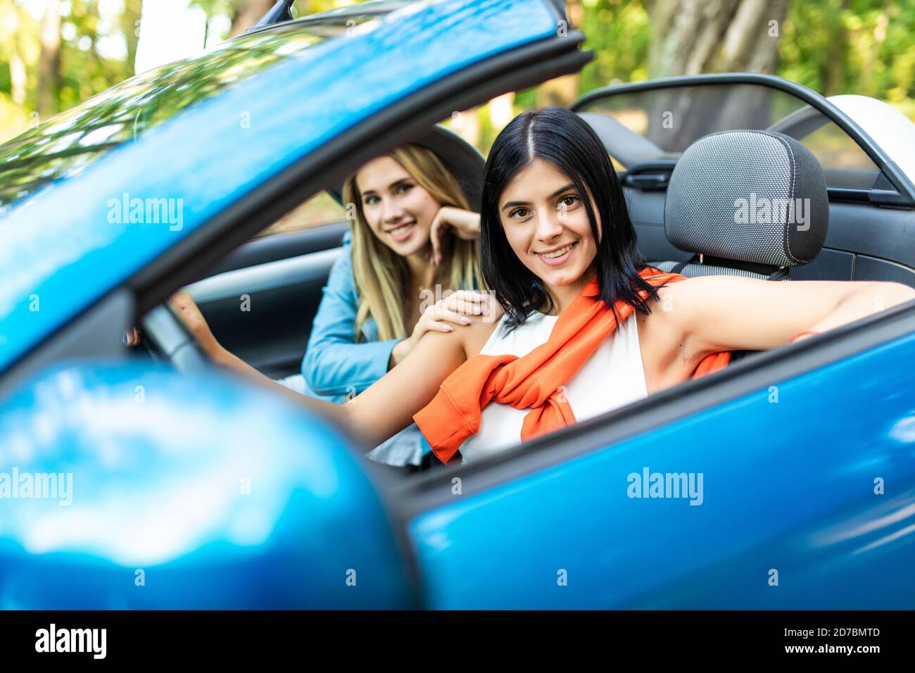 Two Female Friends Driving Open Top Car On Country Road Stock Photo - Alamy