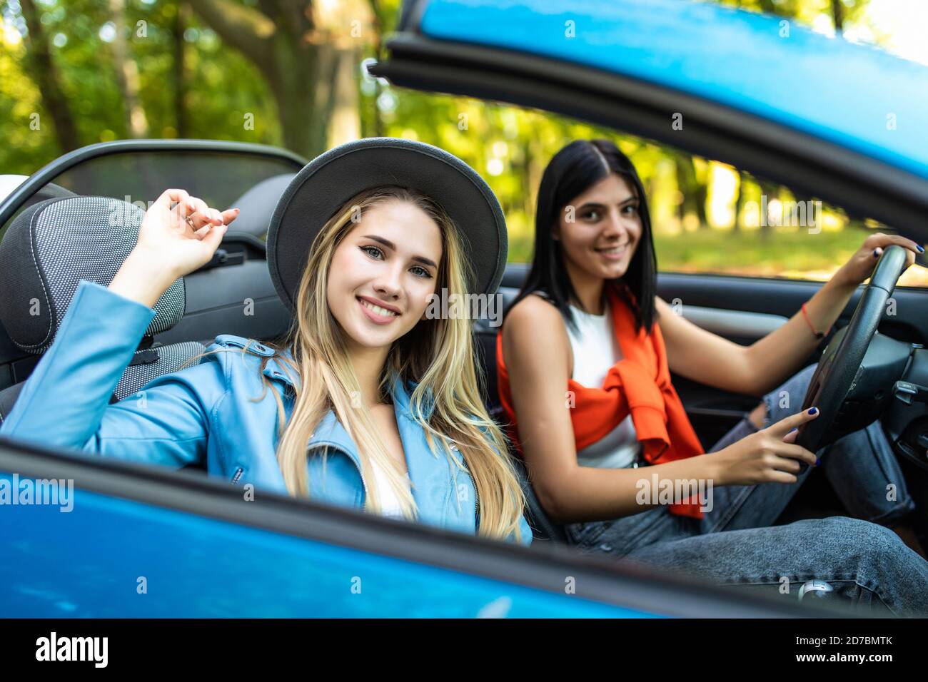 Two Female Friends Driving Open Top Car On Country Road Stock Photo - Alamy