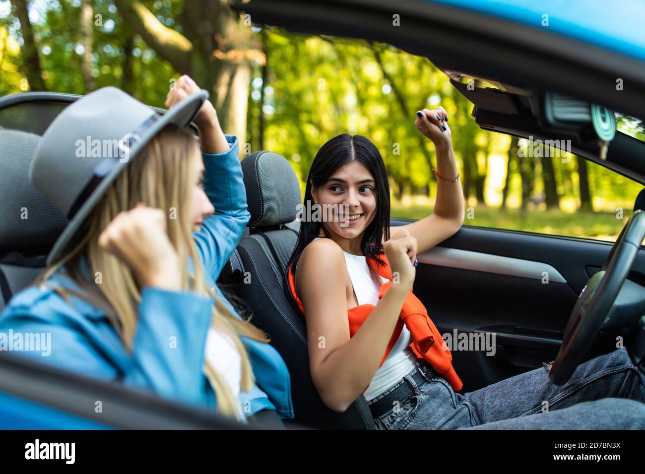 Two attractive young women in a convertible car Stock Photo - Alamy