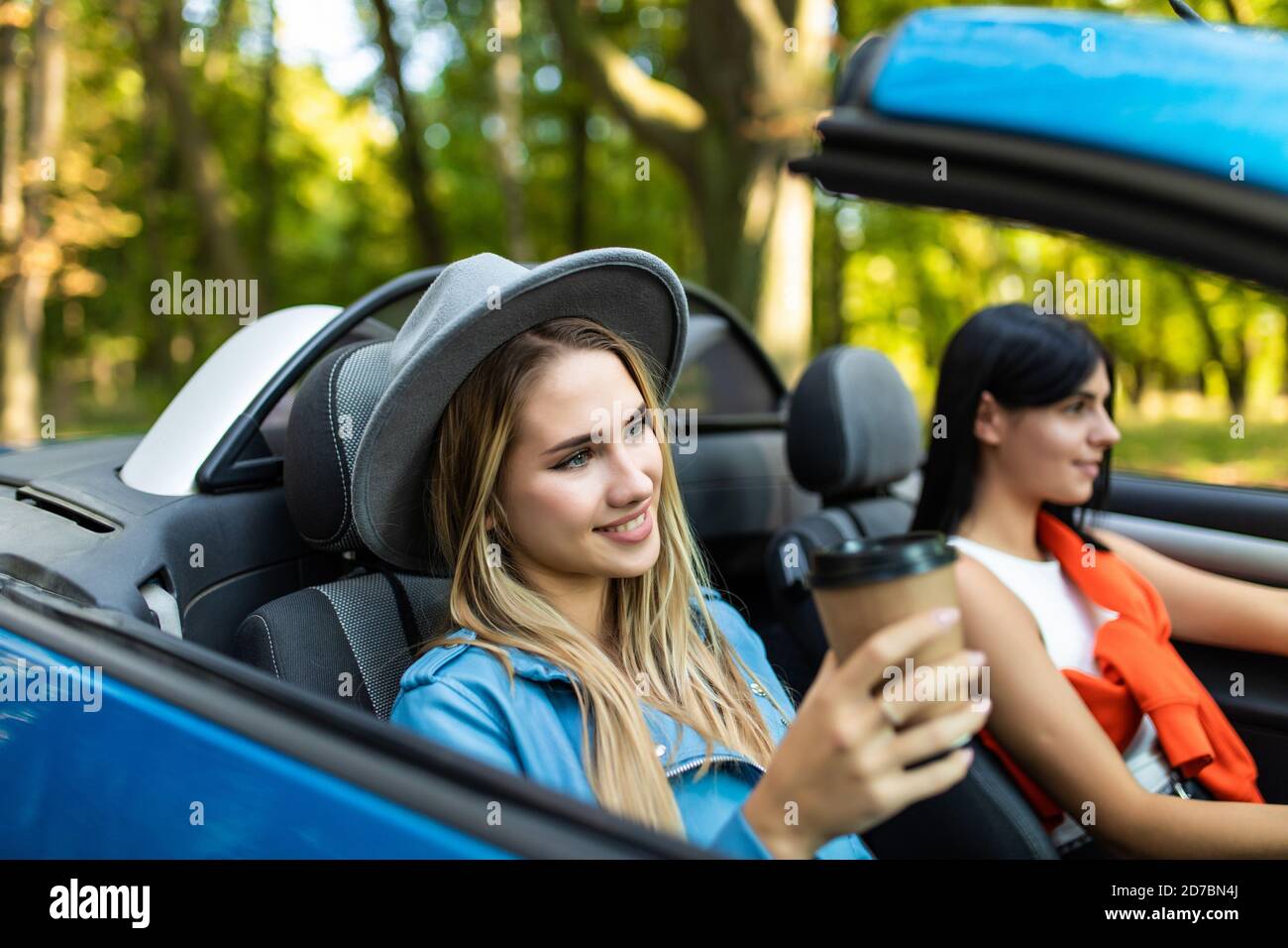 Two young women friends drive car in a road trip Stock Photo - Alamy