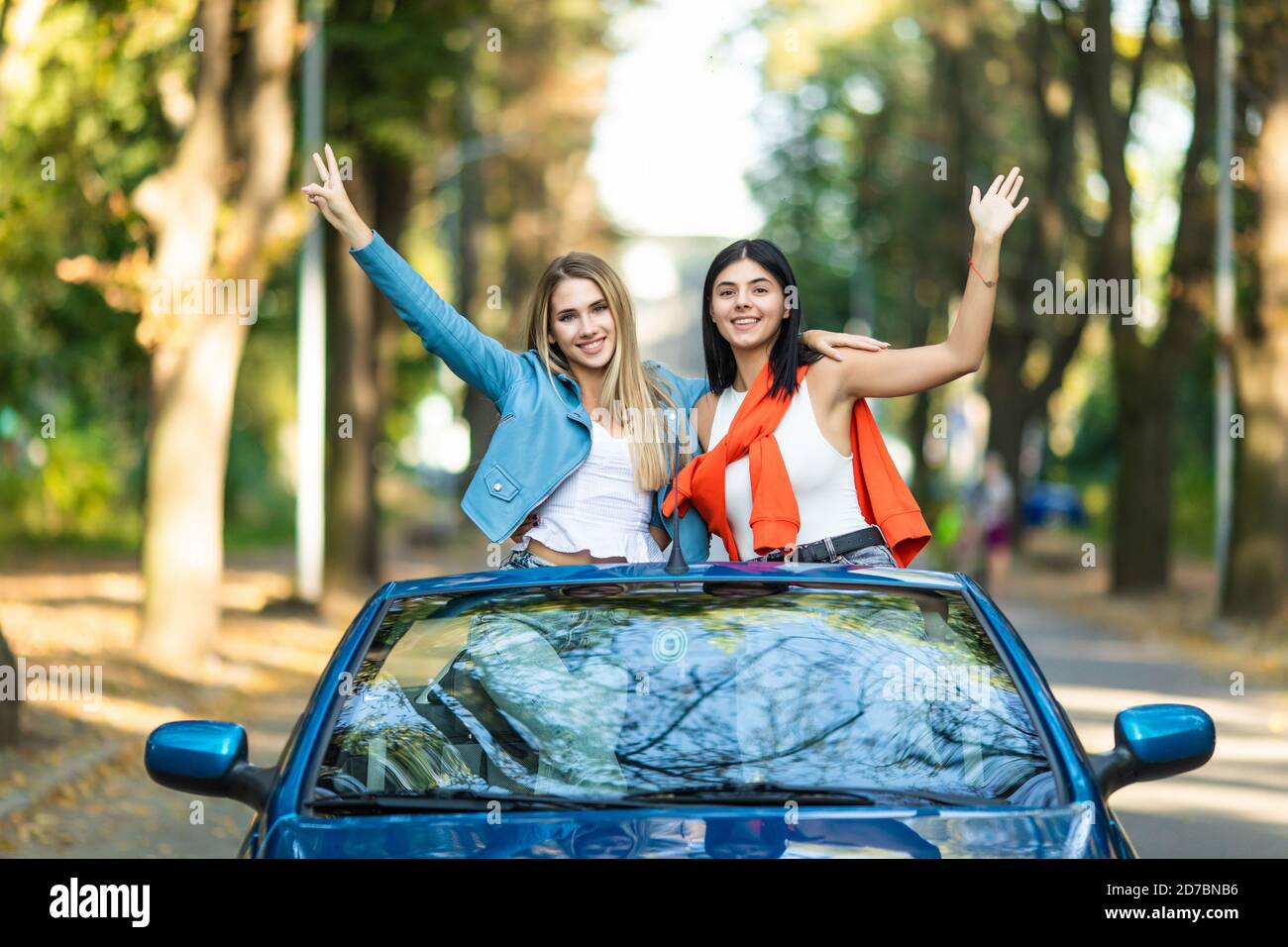 Two attractive young women in a convertible car Stock Photo - Alamy