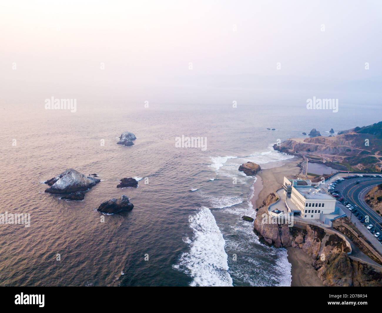 Aerial shot of a white building near the sea with waves splashing Stock ...