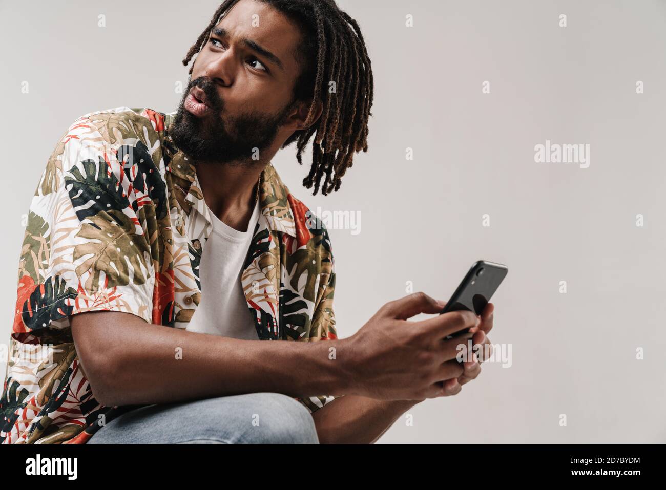 Image of a shocked african guy isolated over grey wall background using ...