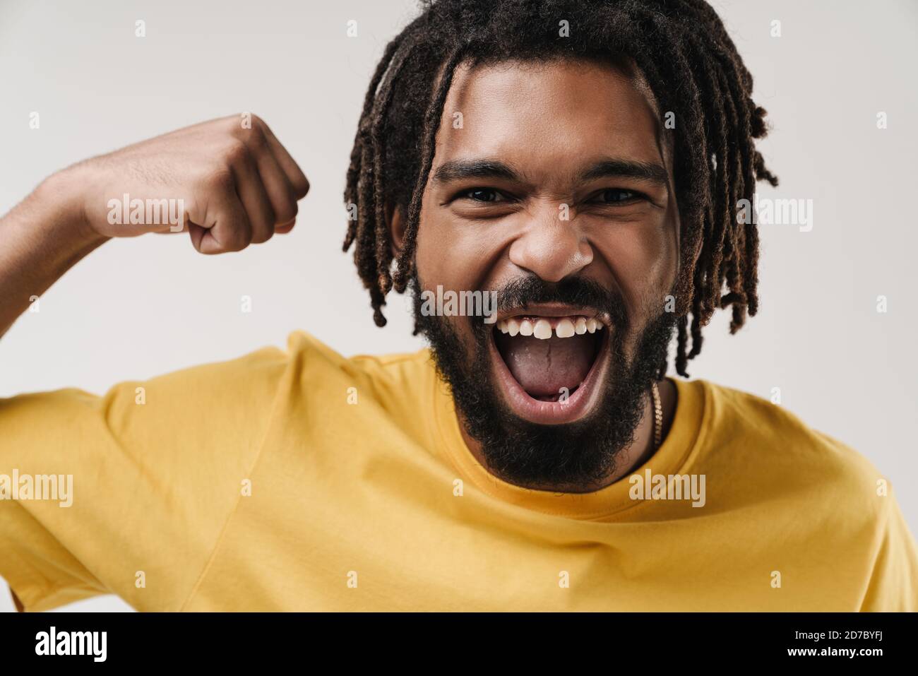 Image of a screaming happy african guy posing isolated over grey wall ...