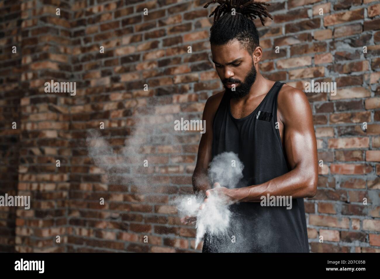 Image of athletic african american sportsman clapping hands with talcum ...