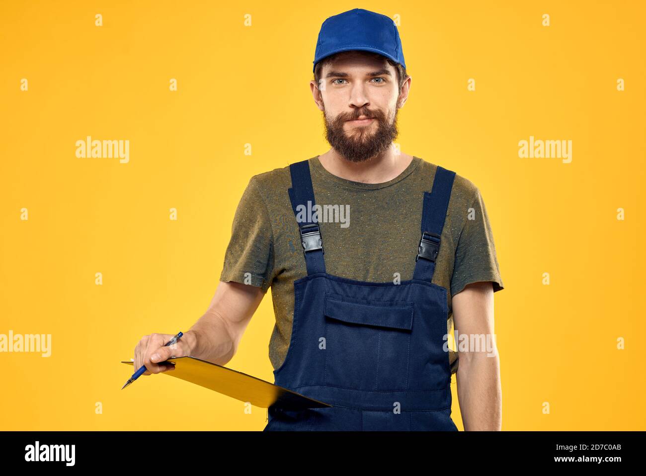 Worker man in uniform worker service yellow background emotion Stock ...