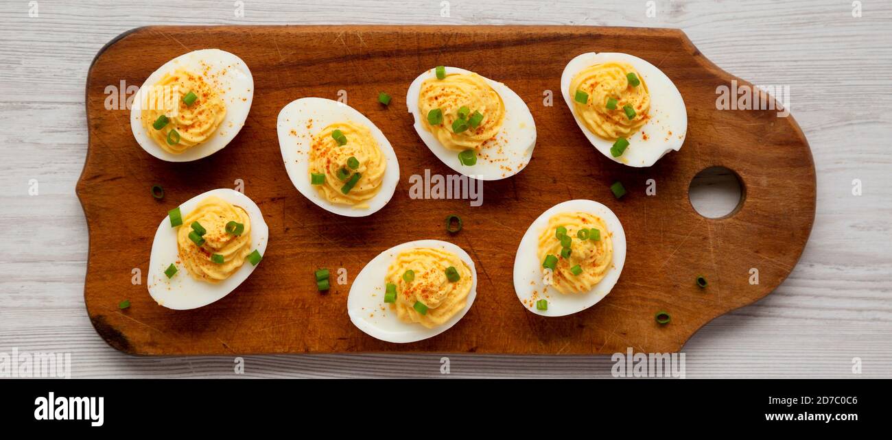 Homemade Deviled Eggs with Chives on a rustic wooden board, view from ...