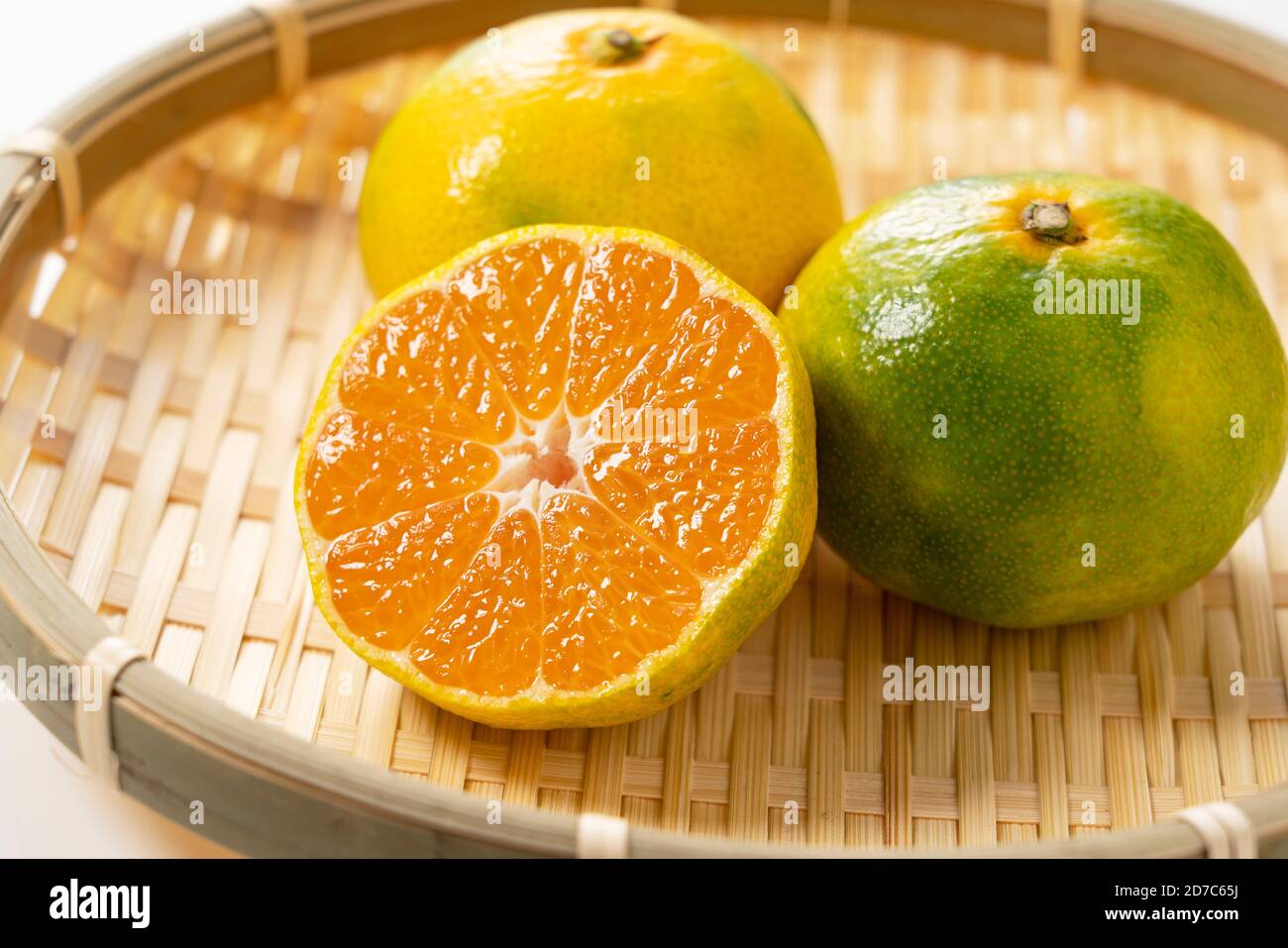 Early cut Japanese mandarin oranges on a colander Stock Photo - Alamy