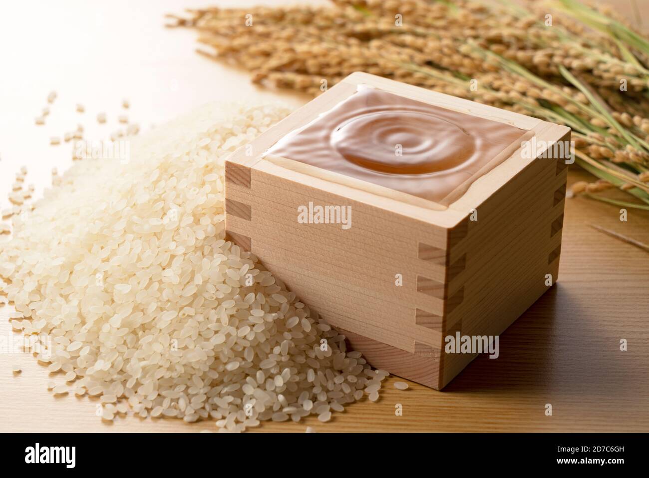 A square box filled with sake. A drop of sake, a ripple. Rice and ears ...