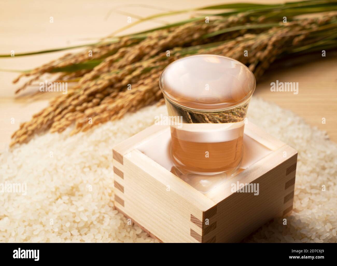 Pour the sake into a sake glass. Rice and ears of rice in the ...