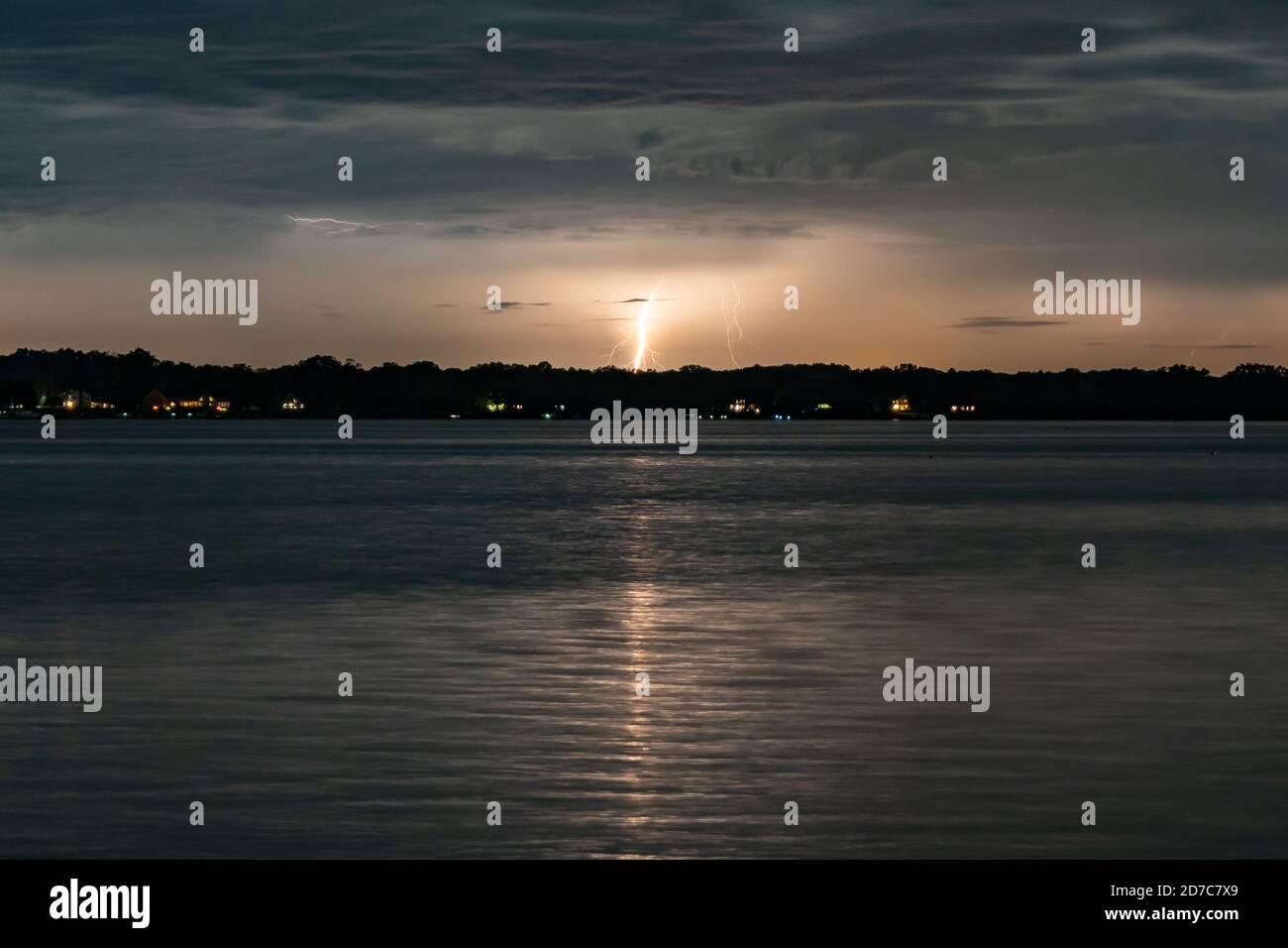Lightning strike over the water with reflection and dark clouds Stock ...