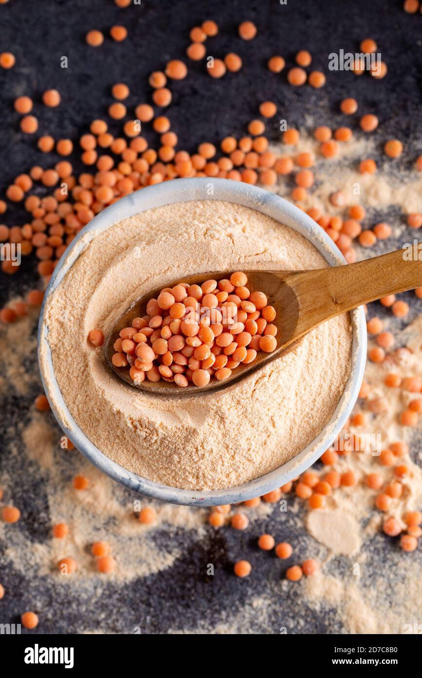 Red lentil and lentil flour in the wooden spoons. Food background Stock ...