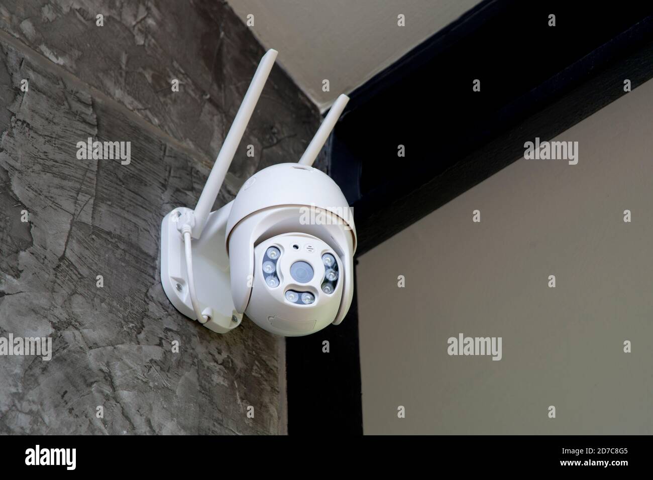 Round shape security camera hanging on wall to monitor movement around ...