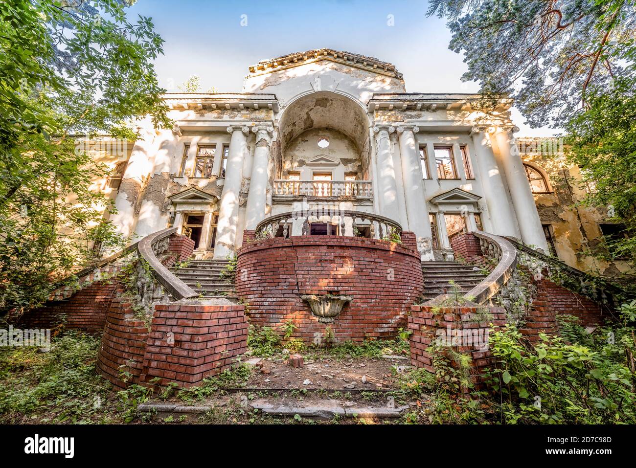 Abandoned dilapidated building in old park. Sweeping staircases ...