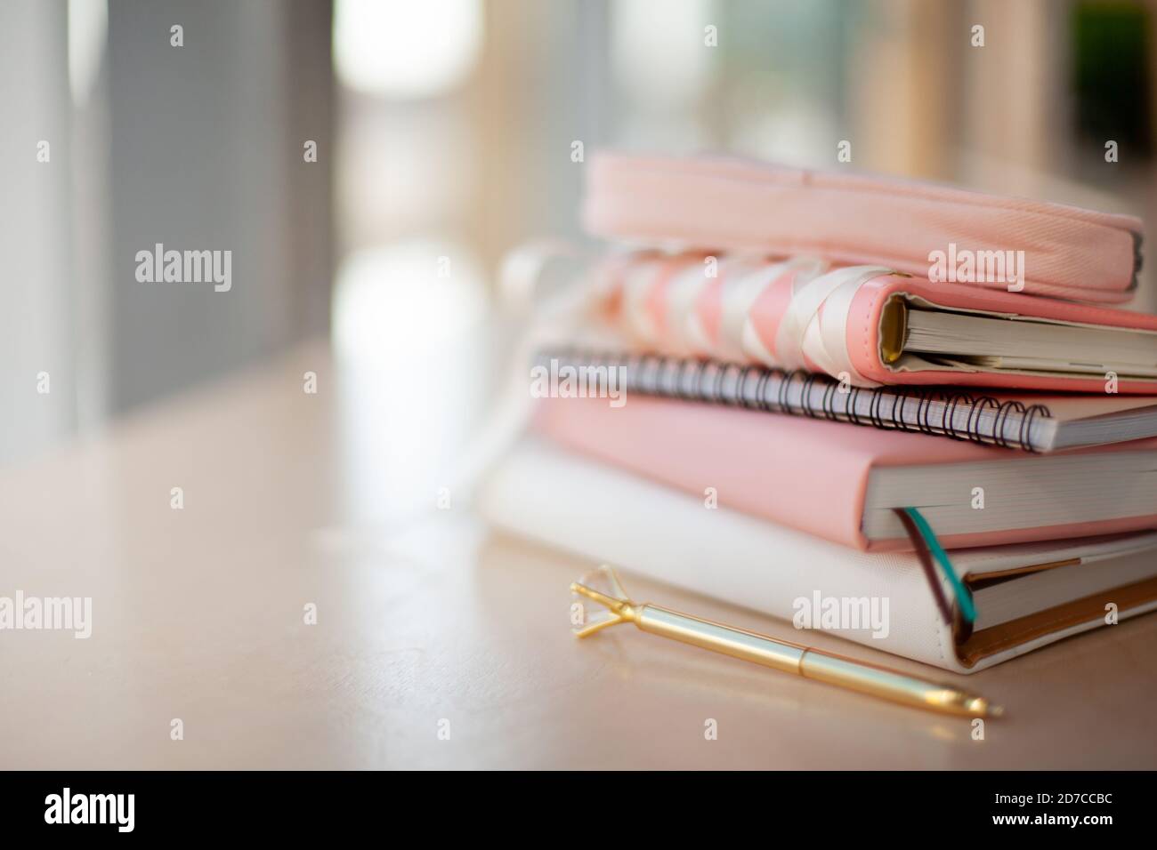 stylish designed coral and white coloured stack of diaries with gold ...