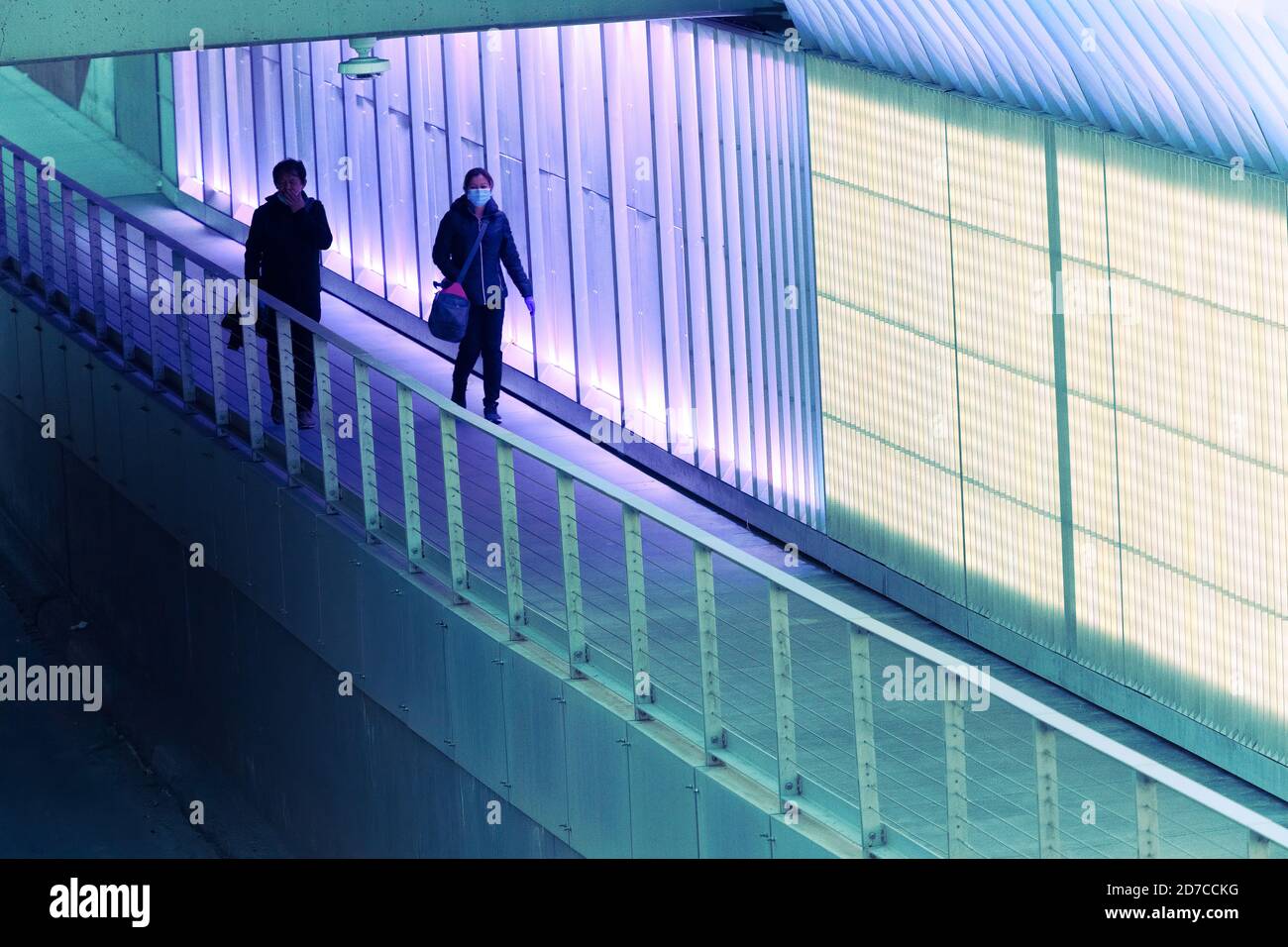 Two pedestrians walking through an underpass with CCTV surveillance ...