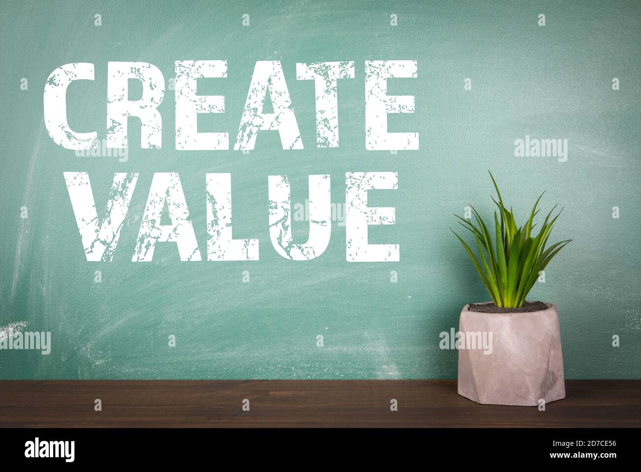 CREATE VALUE. Business and motivation concept. Room plant on a wooden ...