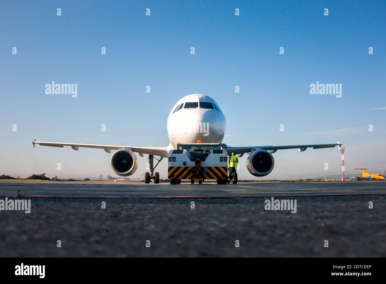 Tow truck is pushing back the passenger airplane Stock Photo - Alamy