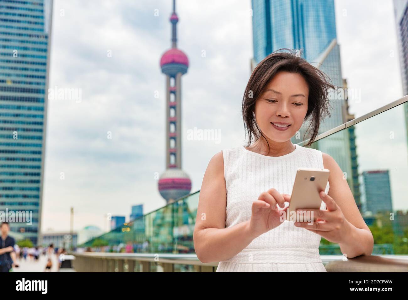 Smartphone business middle aged Asian woman texting on mobile phone ...