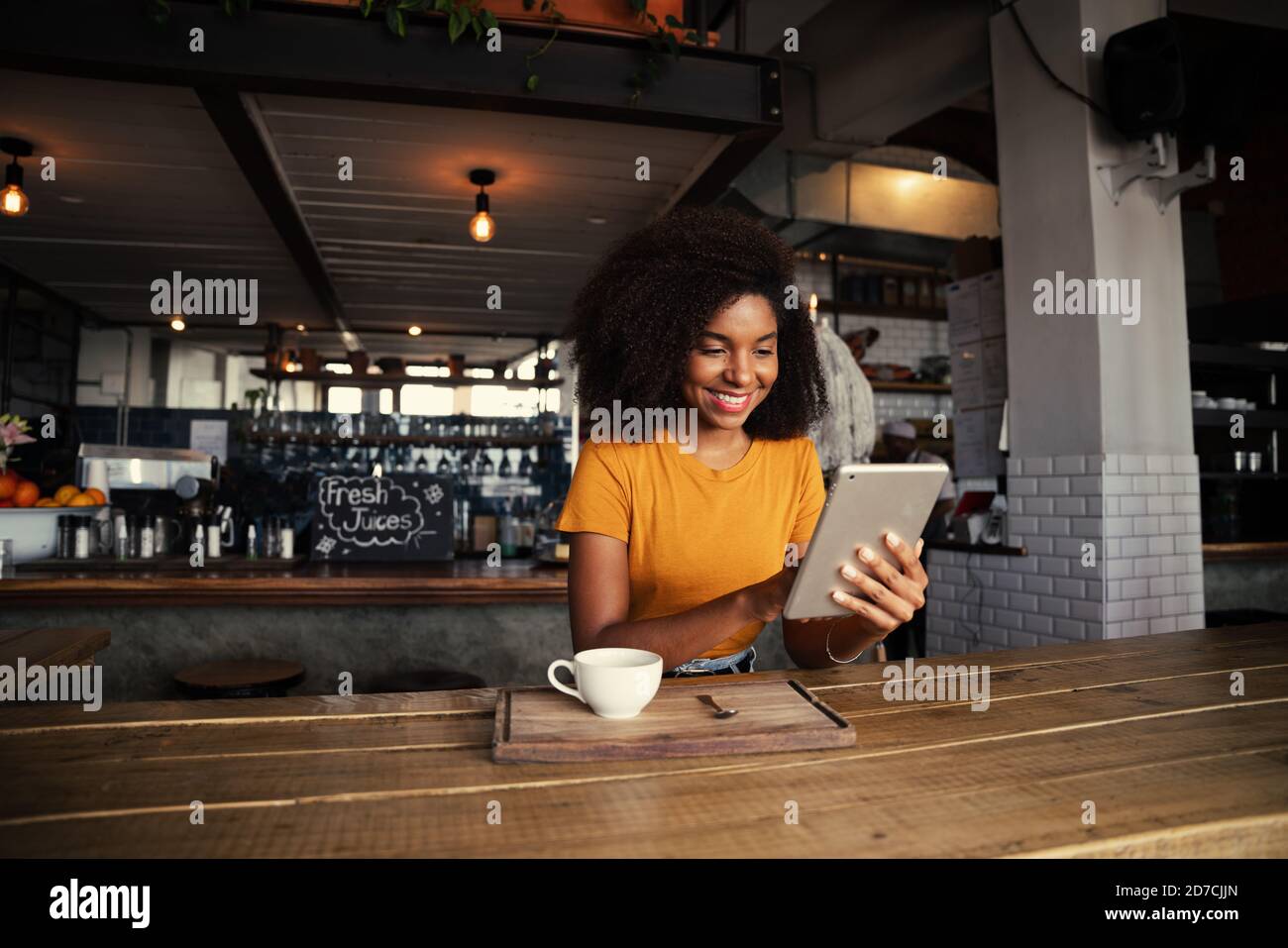 Happy customer choosing meals from menu while enjoying coffee in trendy ...