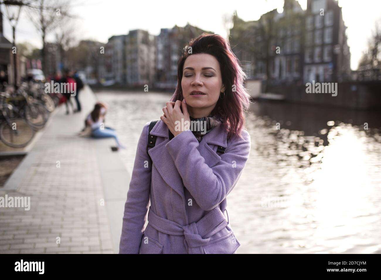 Girl in the coat and backpack enjoying Amsterdam city, Netherlands ...