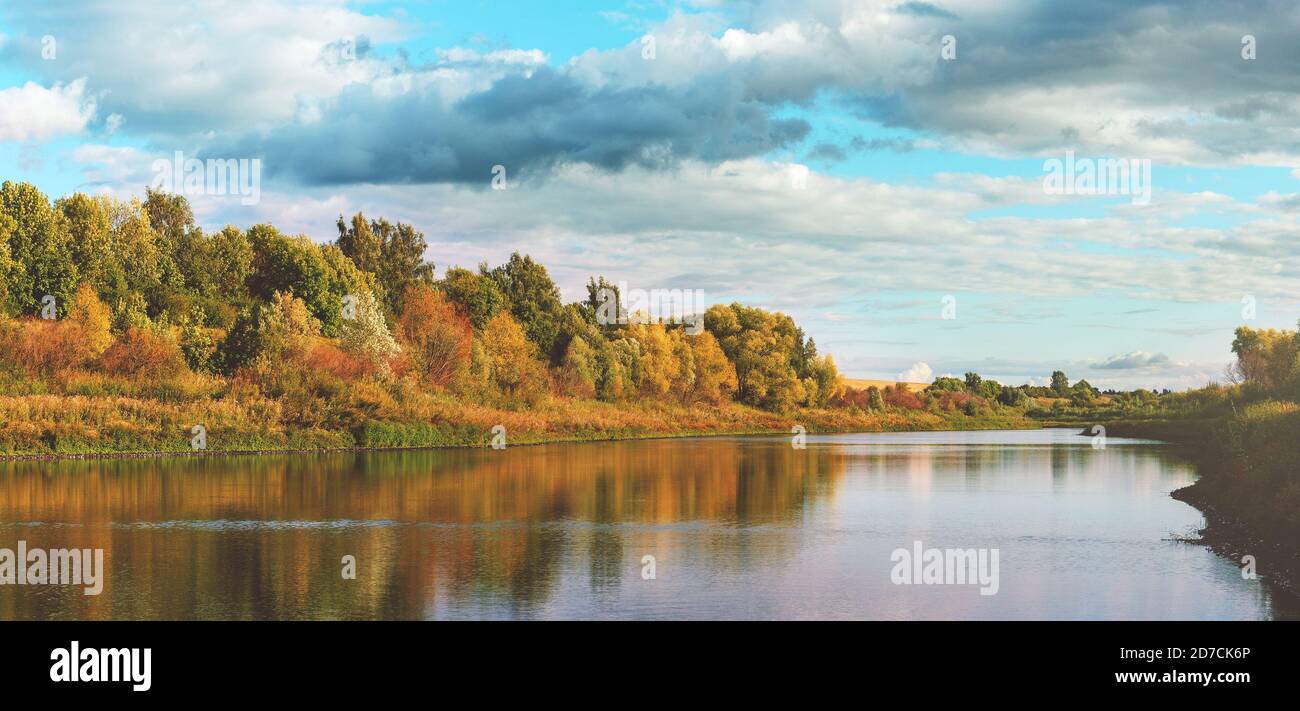Sunny autumn scene with deciduous trees with orange and red leaves ...
