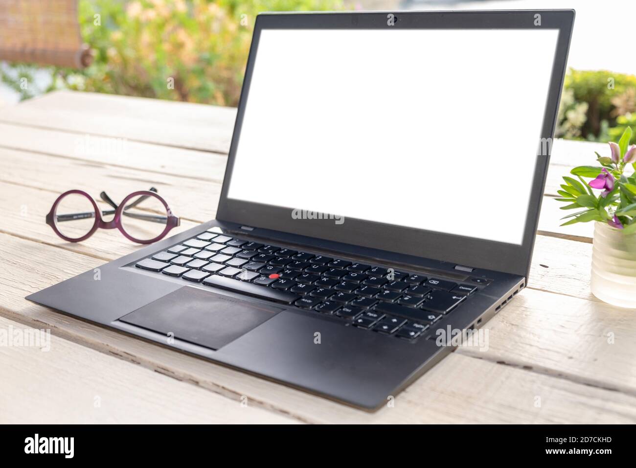 Blank white screen computer on the table, green nature background ...