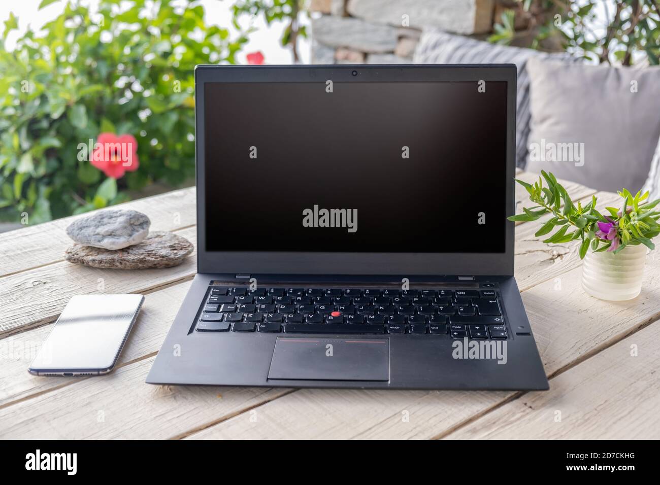 Outdoor office desk, laptop in the garden. Blank screen computer on the ...