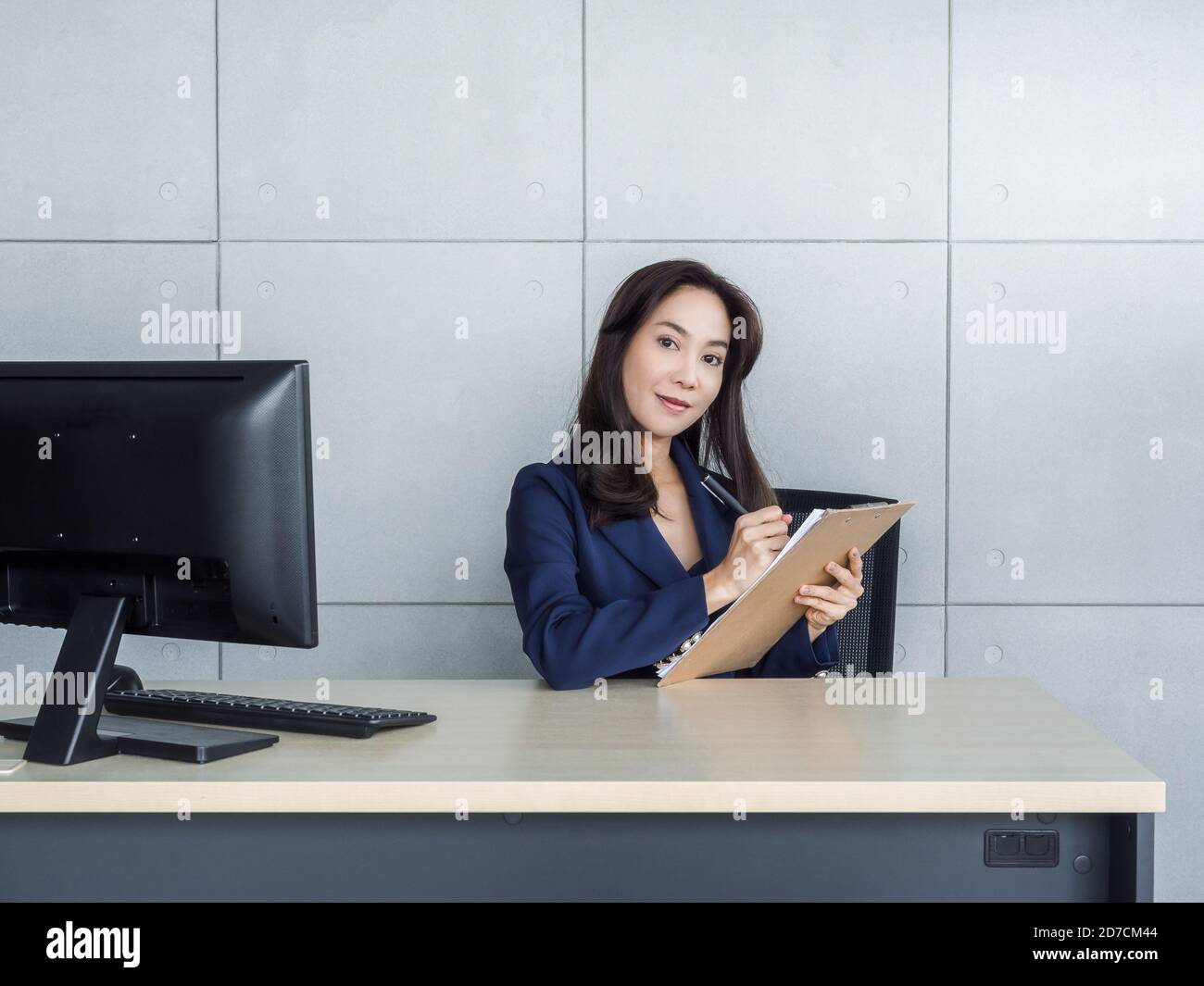 Asian business woman long hair in blue suit working with desktop ...