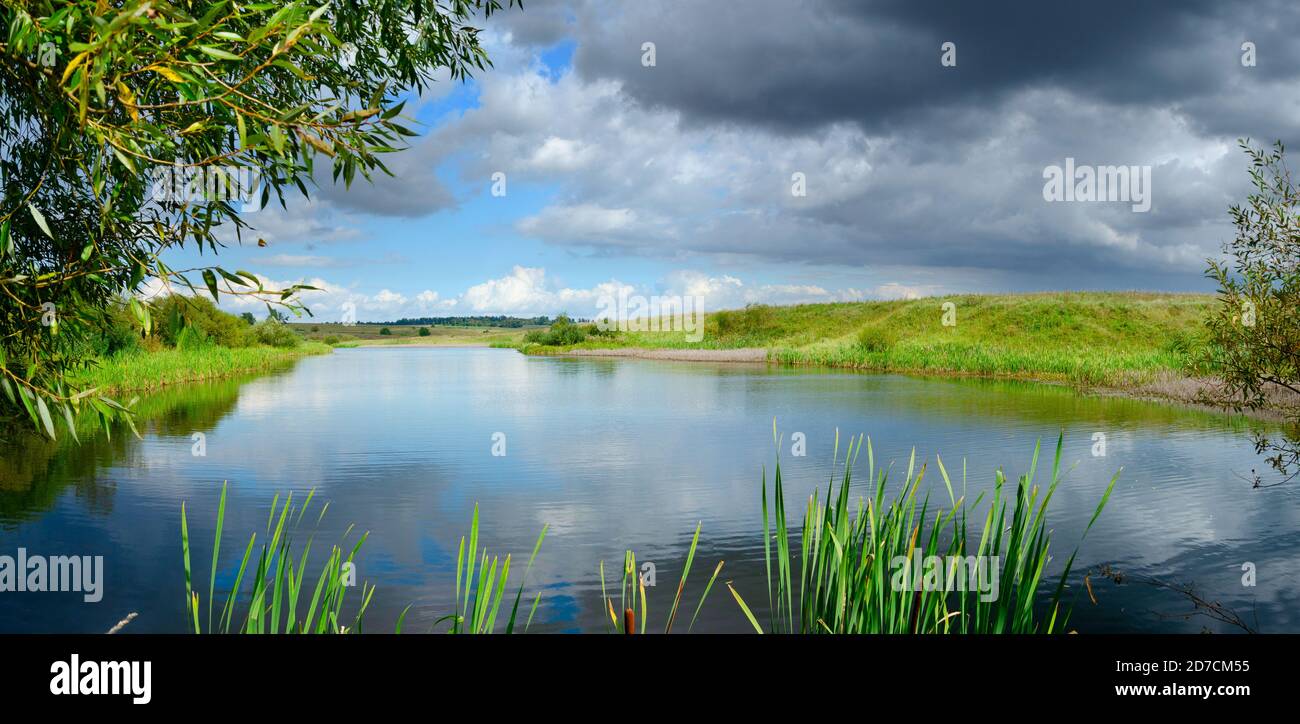 Beautiful panoramic view of river and dark clouds in sky Stock Photo ...