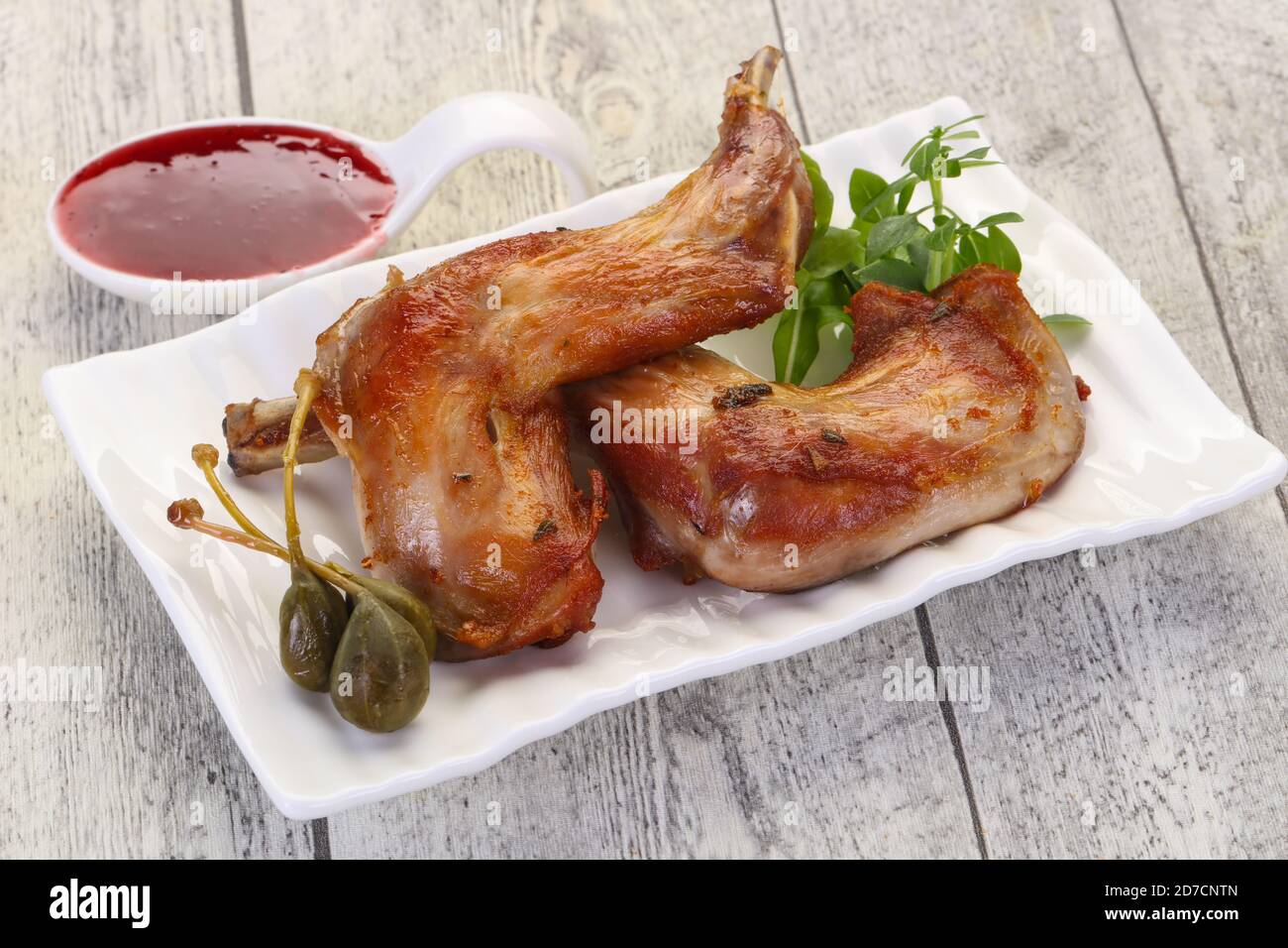 Roasted rabbit legs with cowberry sauce Stock Photo - Alamy