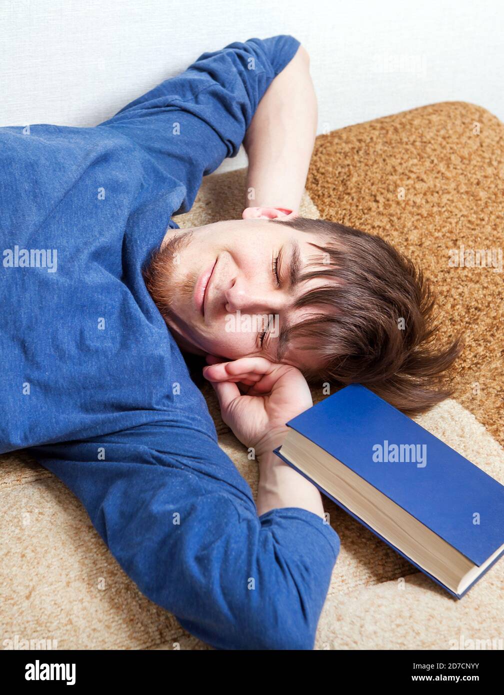 Sleepy and Tired Young Man on the Sofa with a Book Stock Photo - Alamy