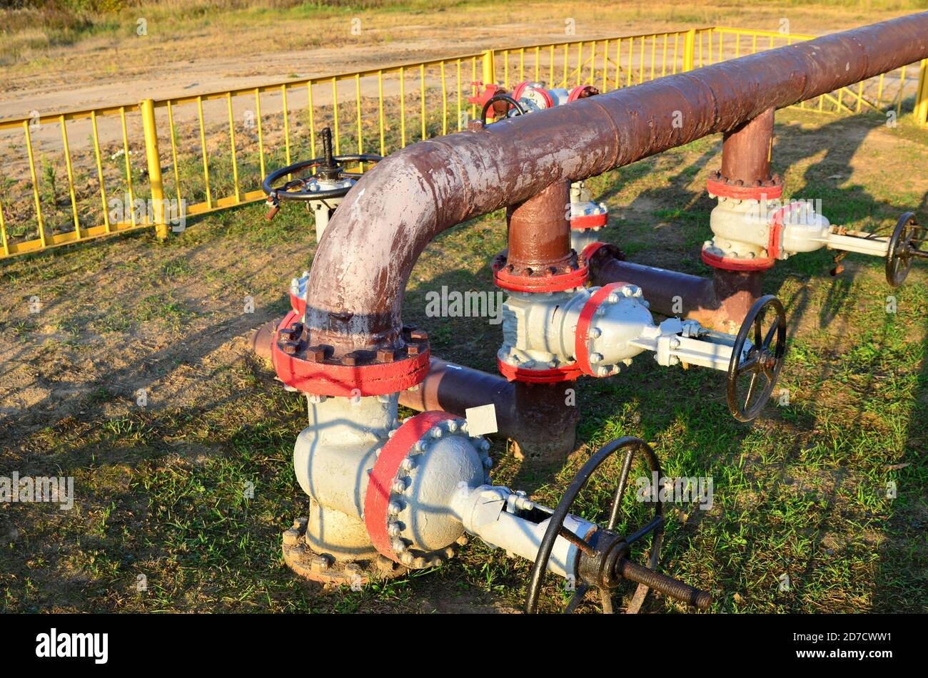 Industrial piping with steel flanges and bolts on oil field. Fuel pipes ...