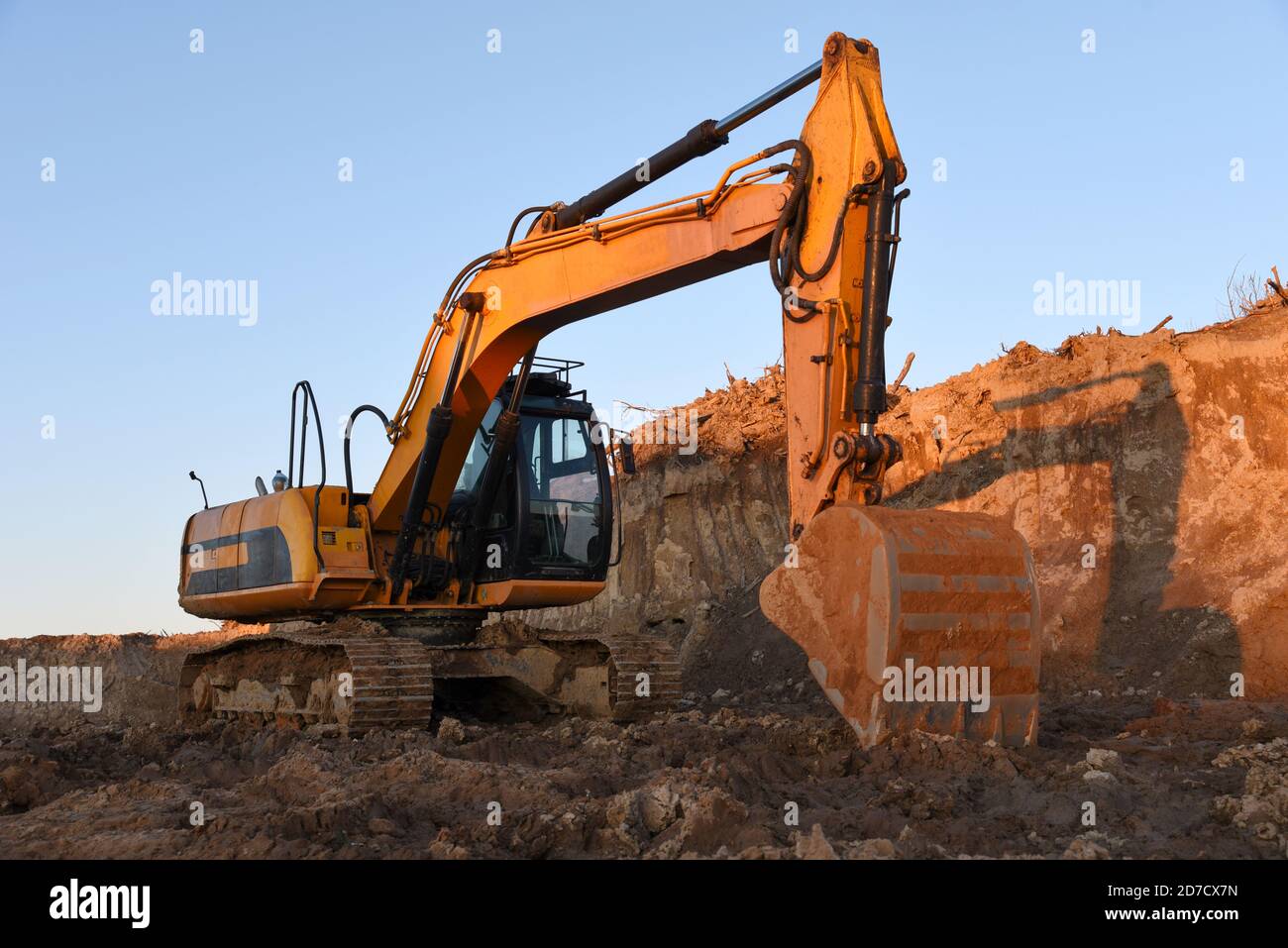 Excavator working on earthmoving. Backhoe digs ground in sand quarry on ...