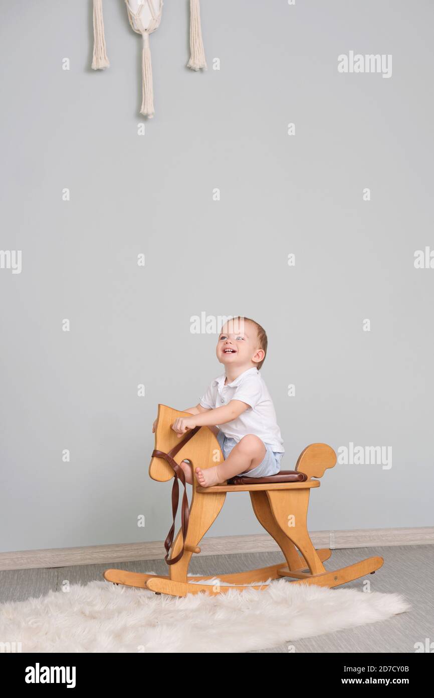 Child Sitting On Ride On Toy In Playroom. Toddler Baby Boy Riding ...