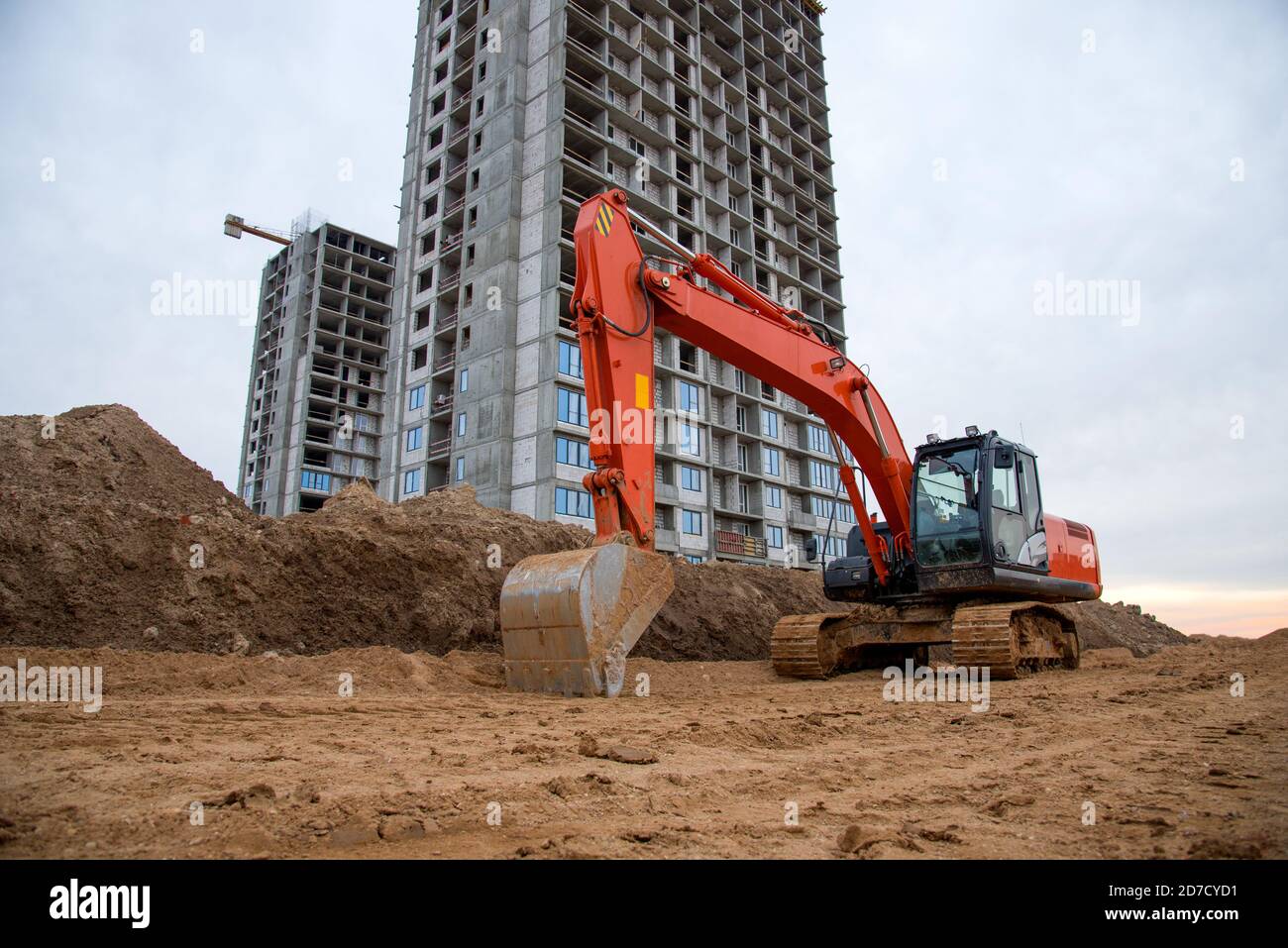 Excavator during earthmoving at construction site. Backhoe digg ground ...